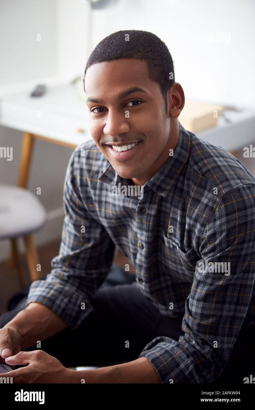 Portrait Of Smiling Male Student In Bedroom Of Rented House Stock Photo ...