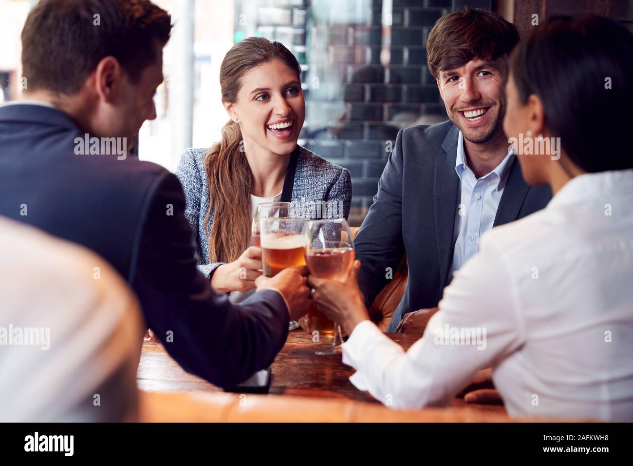 Group Of Business Colleagues Making A Toast As They Meet For Drinks And ...