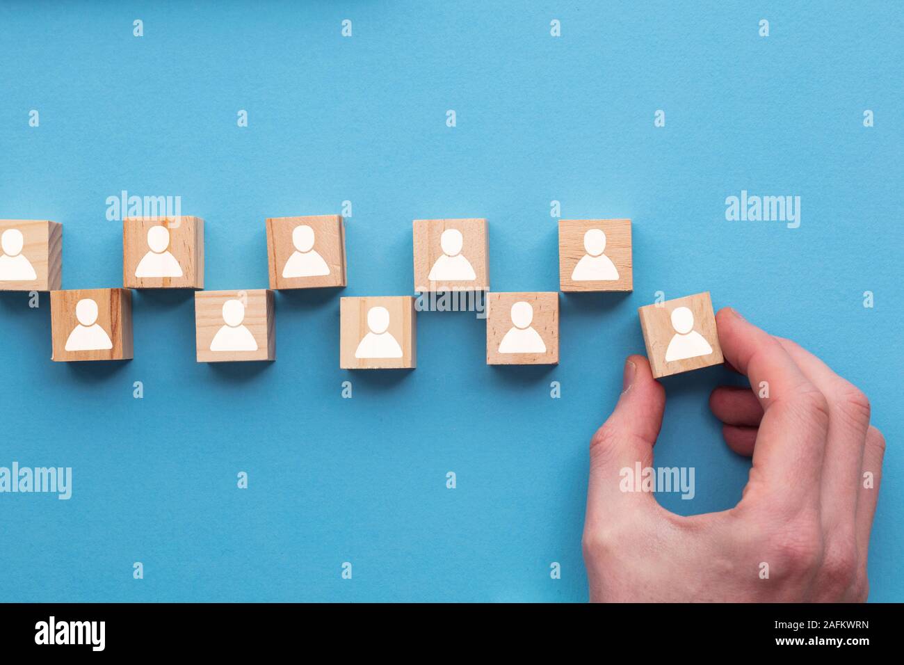 Hand choosing a wooden person block from a set. Employment choice ...