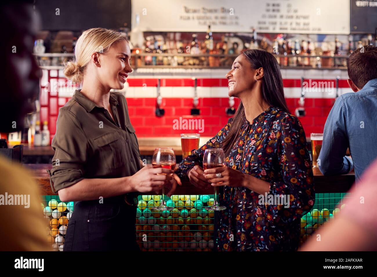 Two Women Meeting For Drinks And Socializing In Bar After Work Stock ...