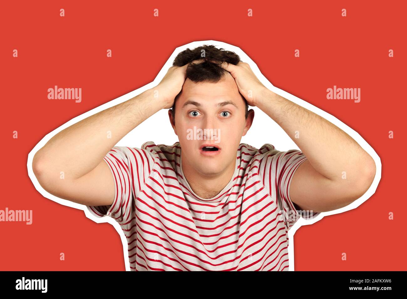 Shocked dazed young man in t-shirt holding head with both hands ...