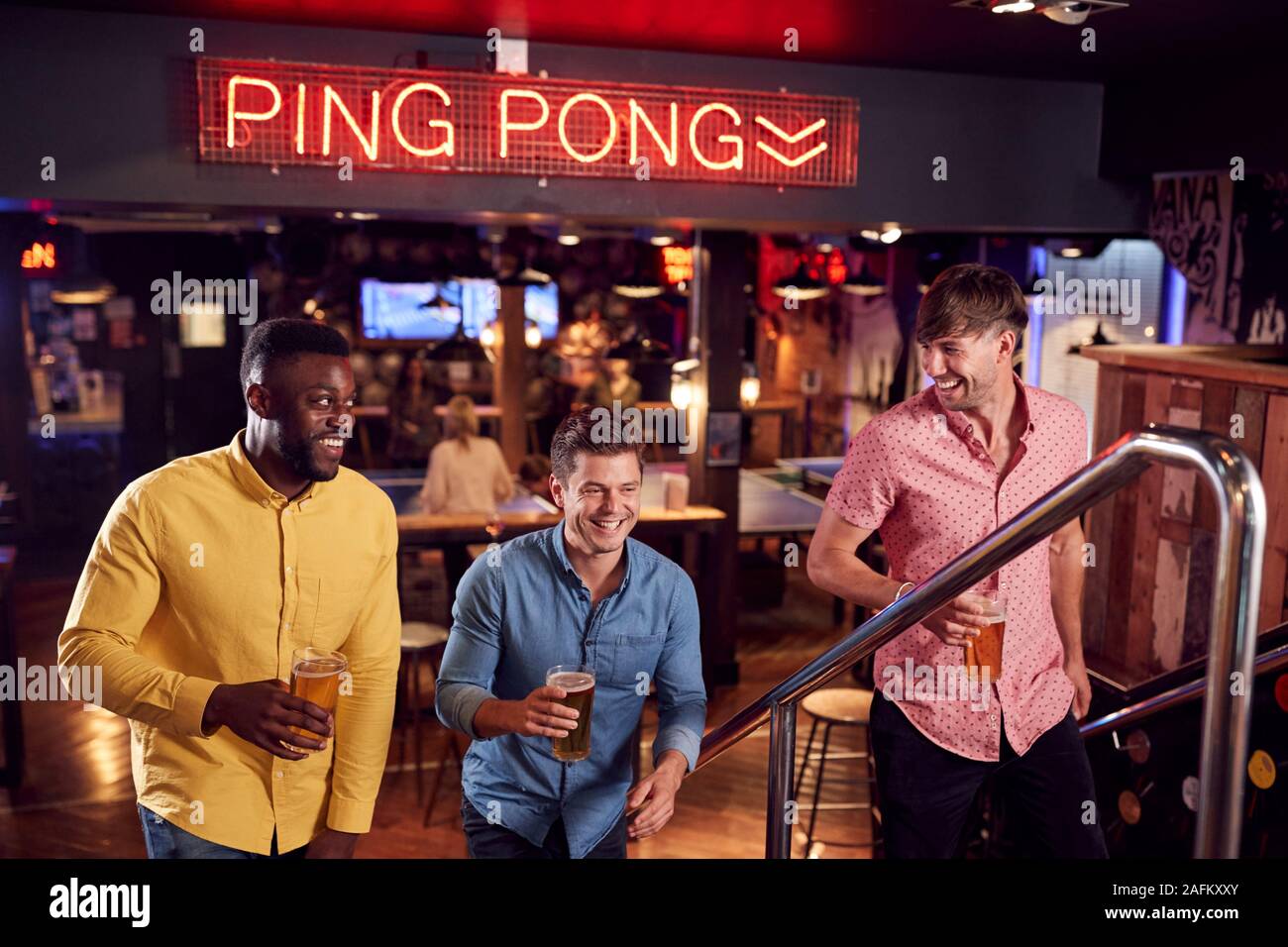 Three Male Friends Climbing Stairs As They Meet For Drinks And ...