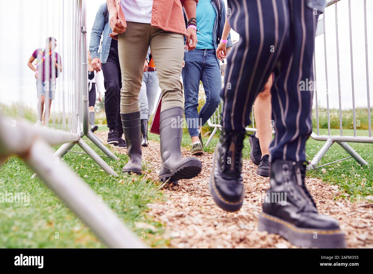 Close Up Of Friends At Entrance To Music Festival Walking Through ...