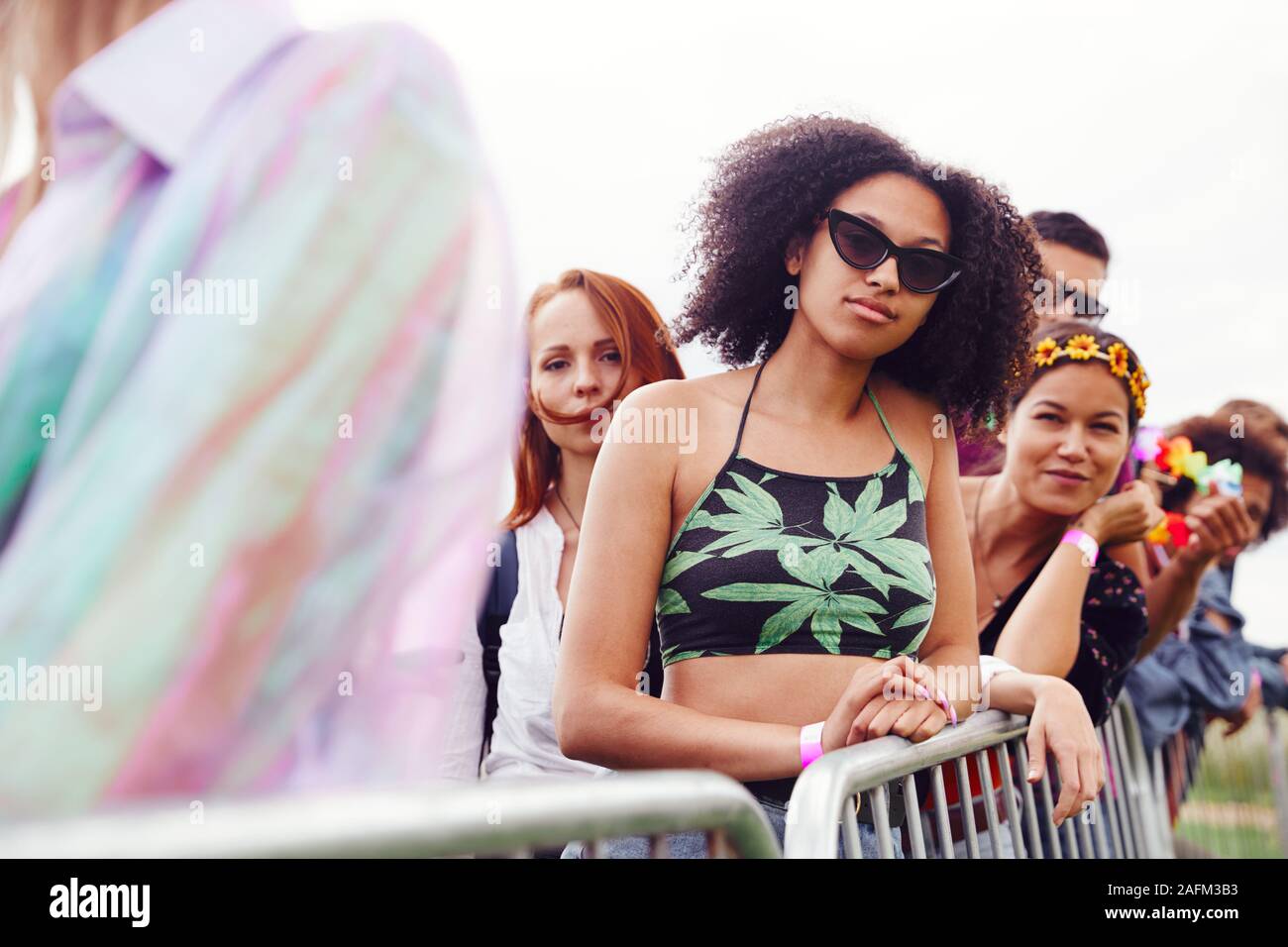 Group Of Young Friends Waiting Behind Barrier At Entrance To Music ...