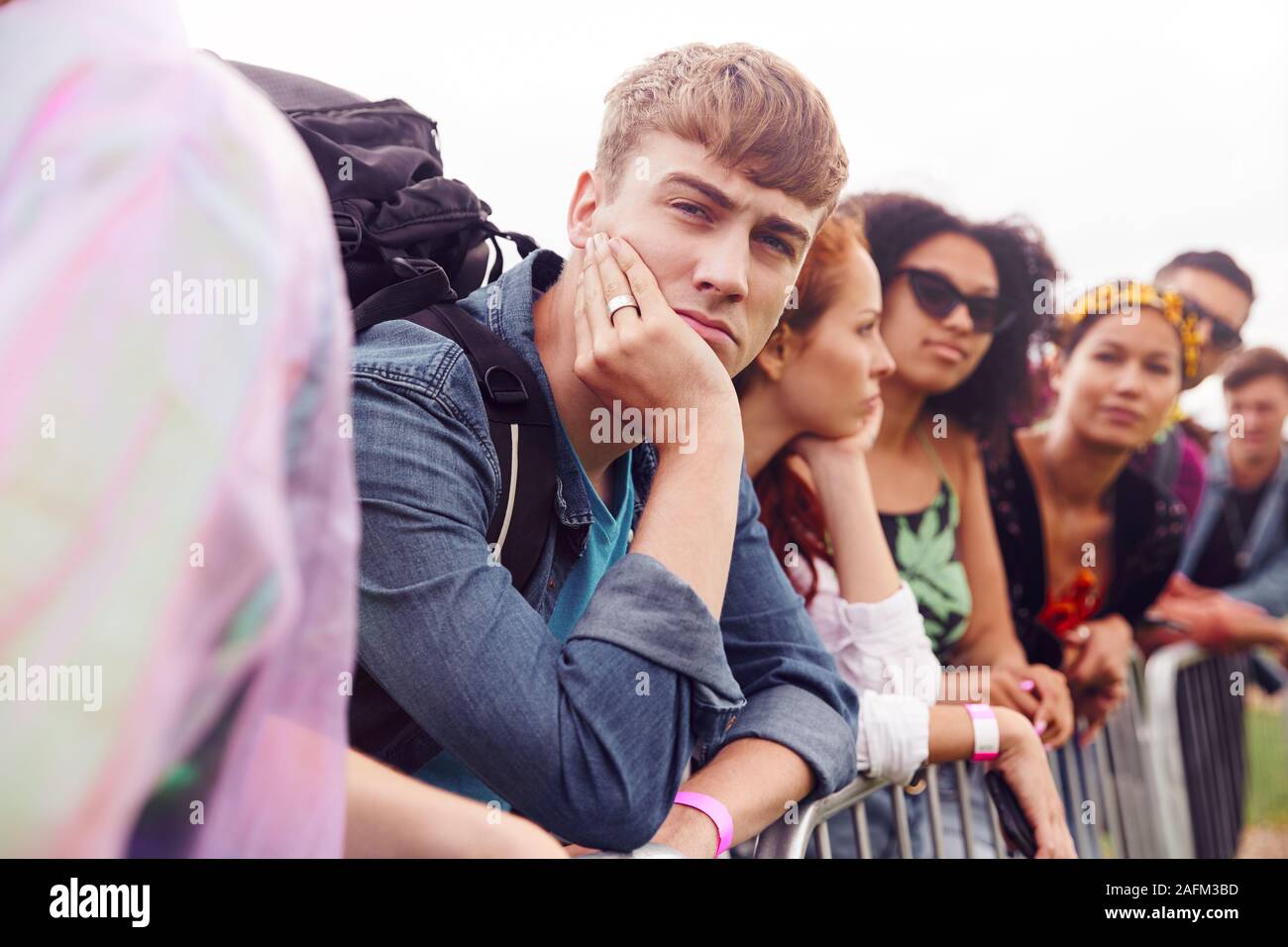 Group Of Young Friends Waiting Behind Barrier At Entrance To Music ...