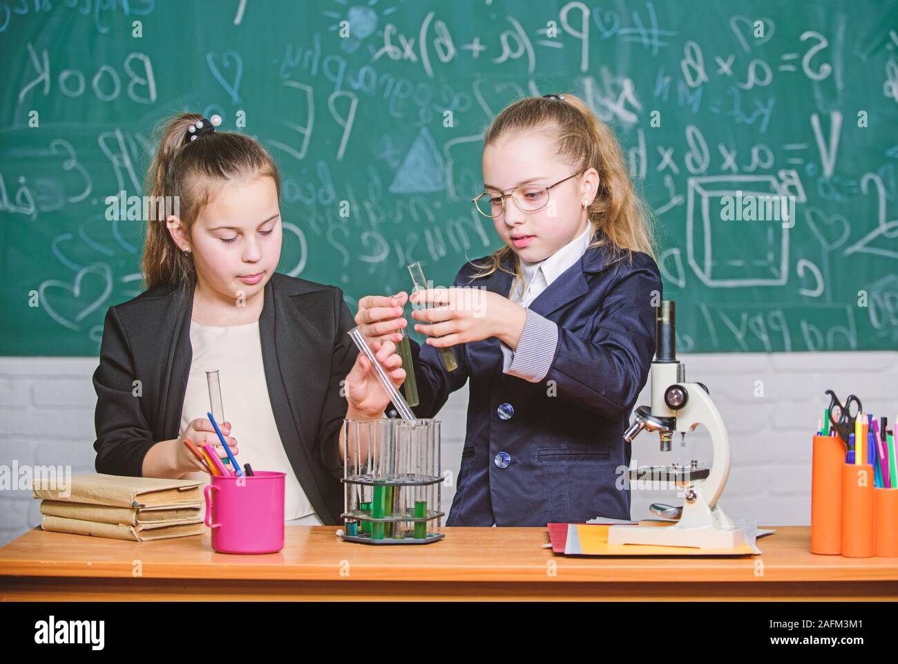 Confident medical experts. Little girls in school lab. Formal school ...