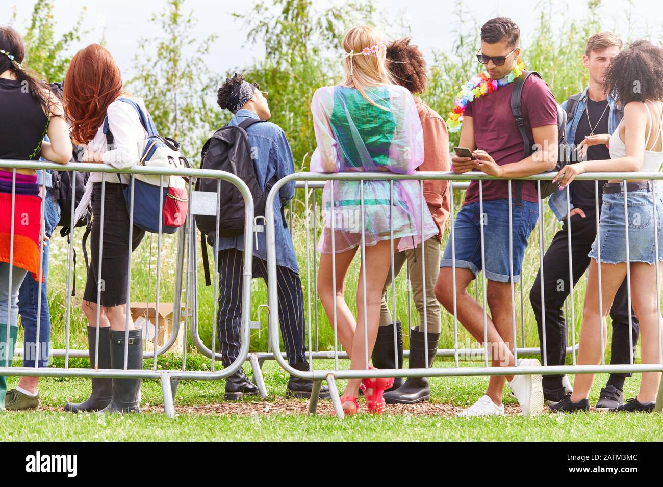 Group Of Young Friends Waiting Behind Barrier At Entrance To Music ...