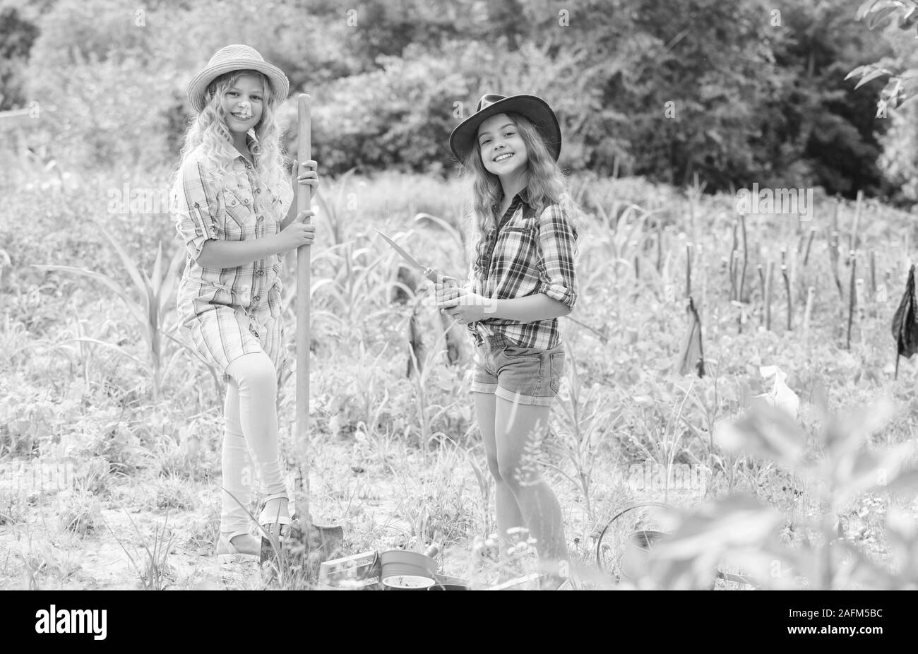 Sisters together helping at farm. Girls planting plants. Rustic ...