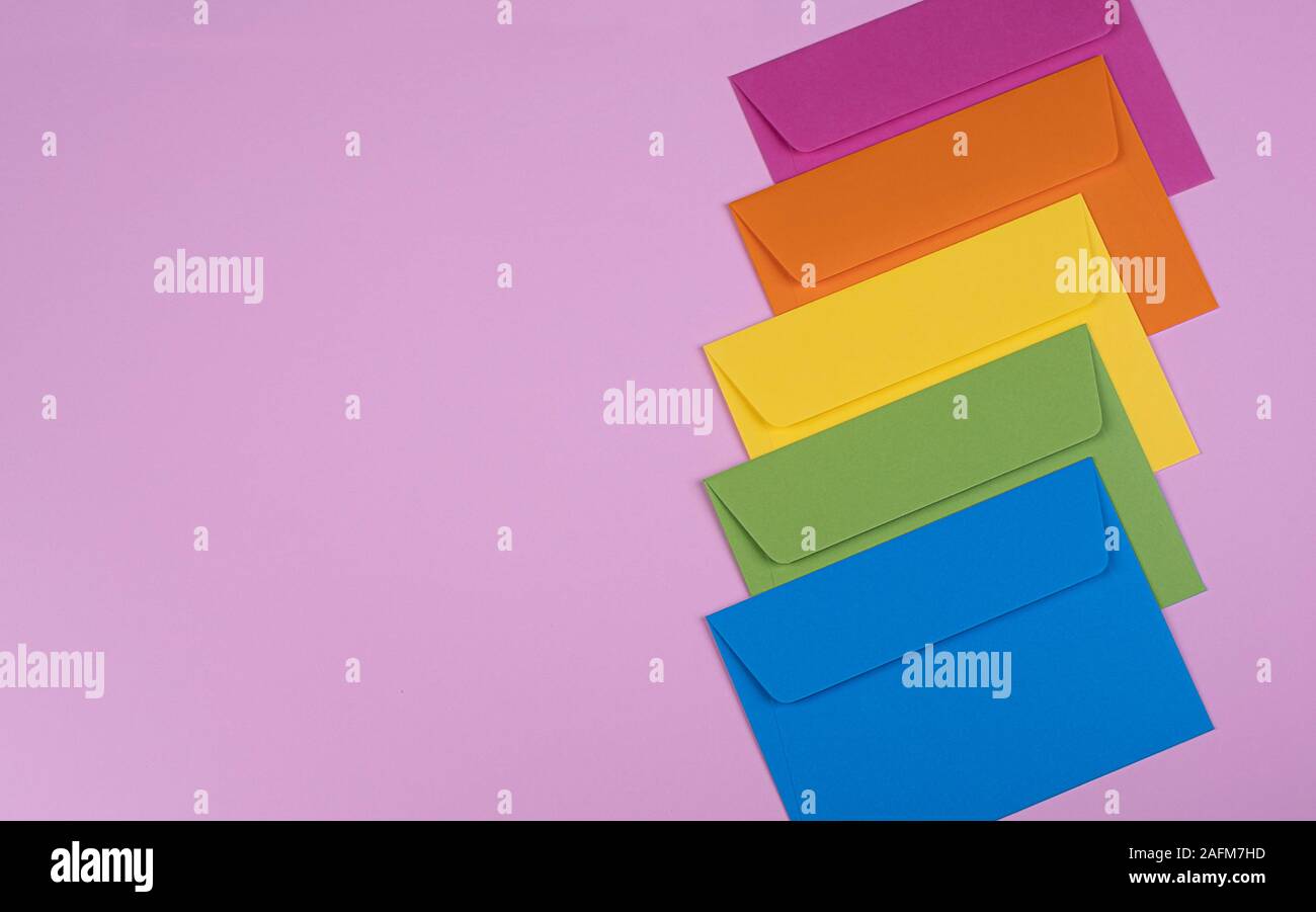 tidy coloured envelopes on a light pink background Stock Photo - Alamy