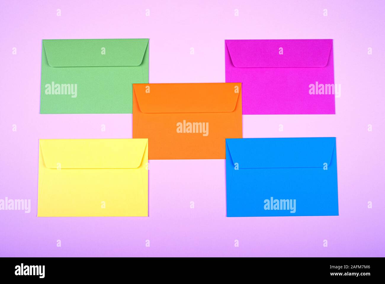 tidy coloured envelopes on a light pink background Stock Photo - Alamy