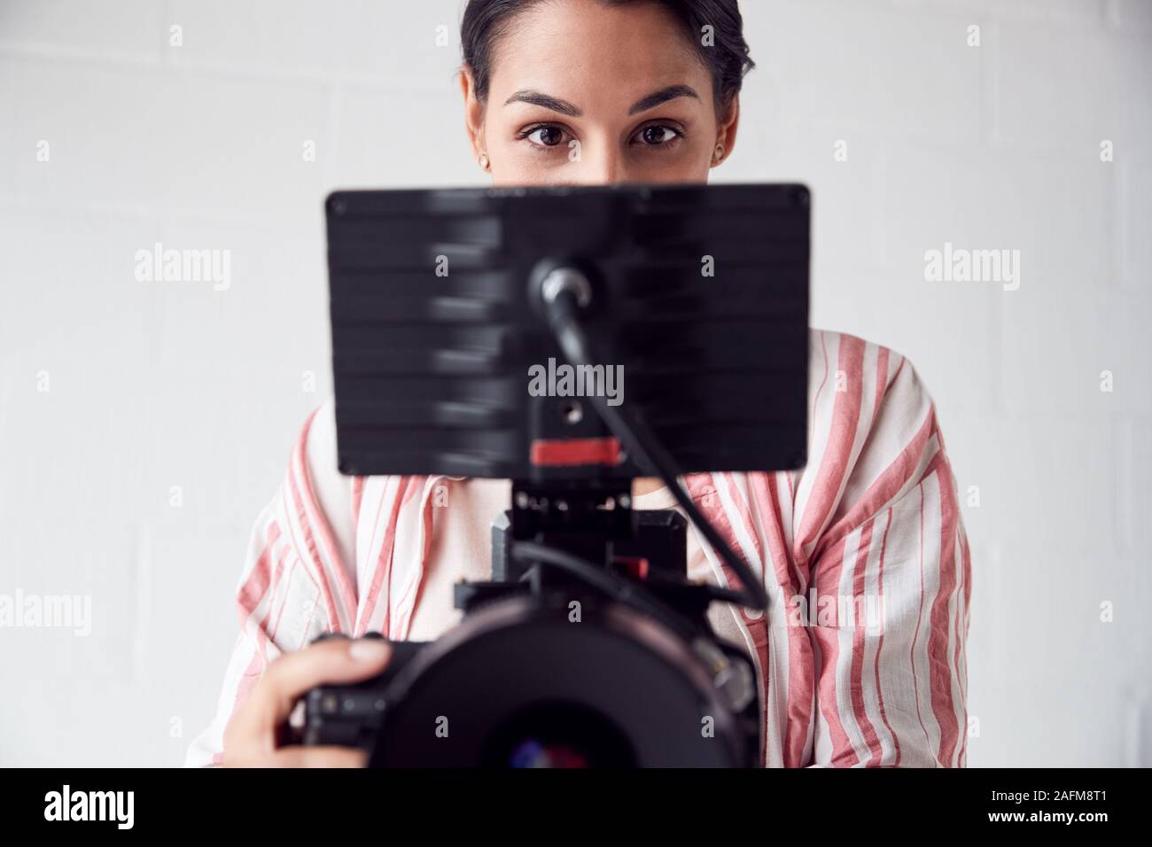 Female Videographer With Video Camera Filming Movie In White Studio ...