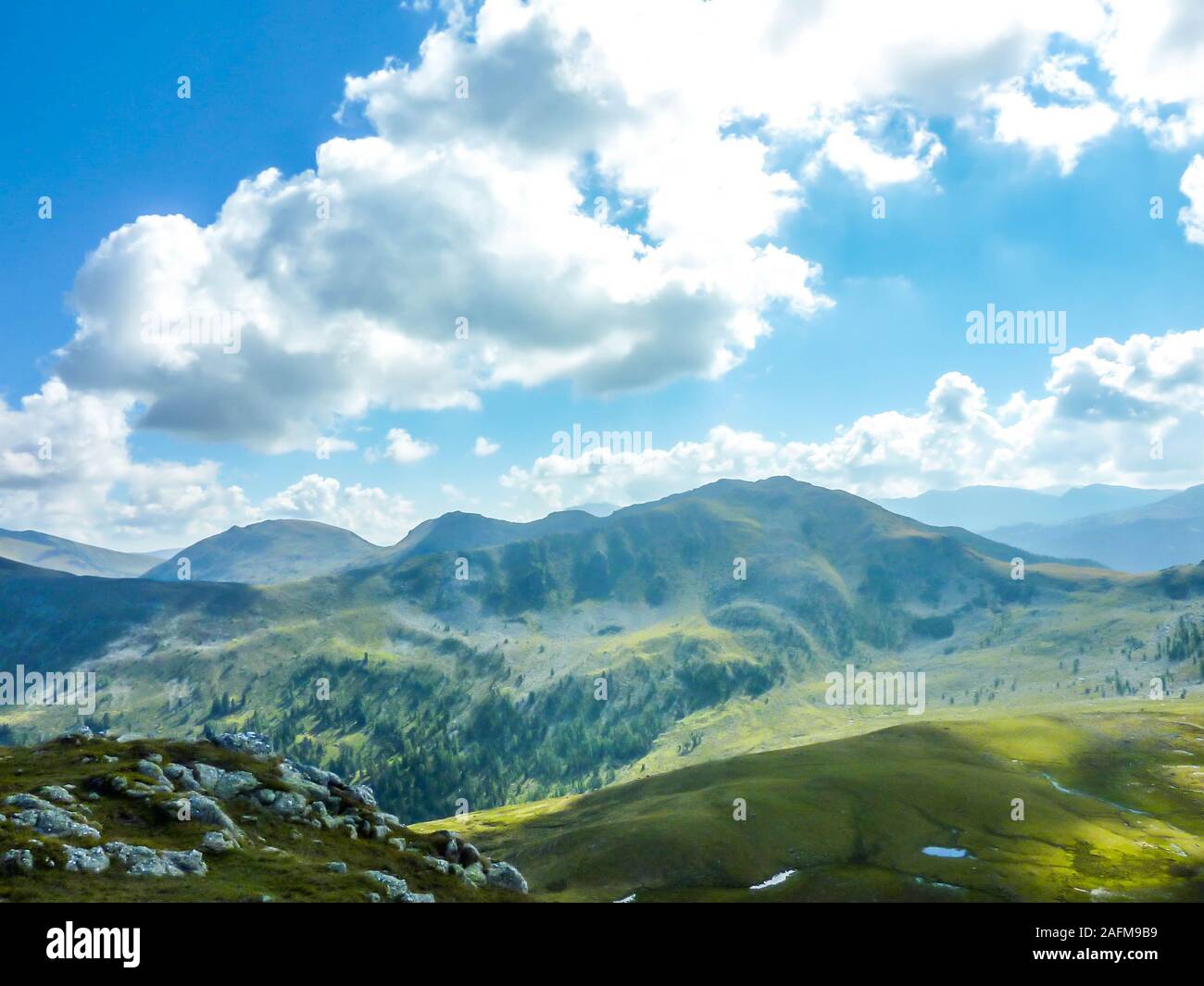 Hiking trails in the high mountain. Lush green grass covers the slopes ...