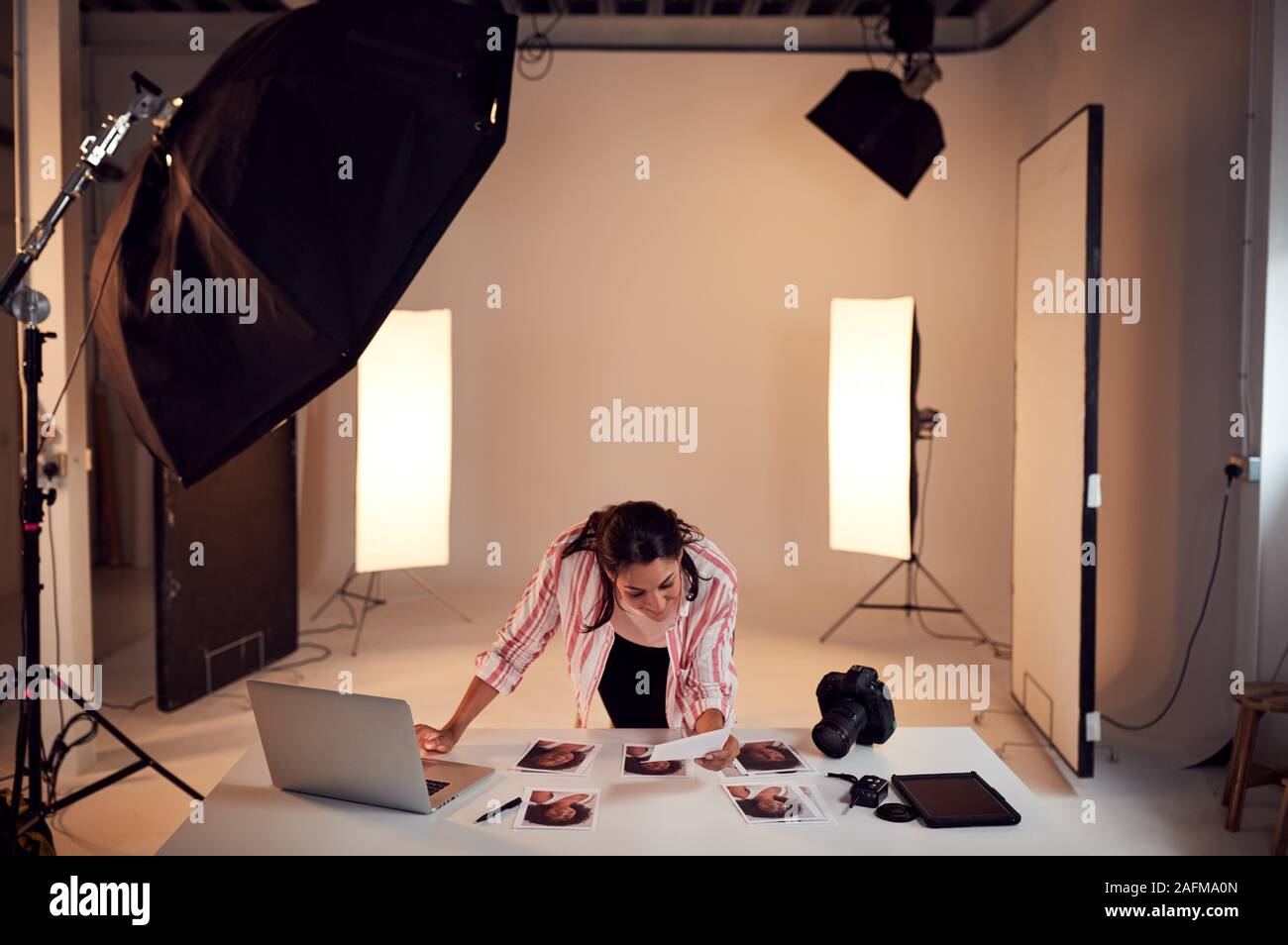 Female Photographer Editing Images From Photo Shoot In Studio Stock ...