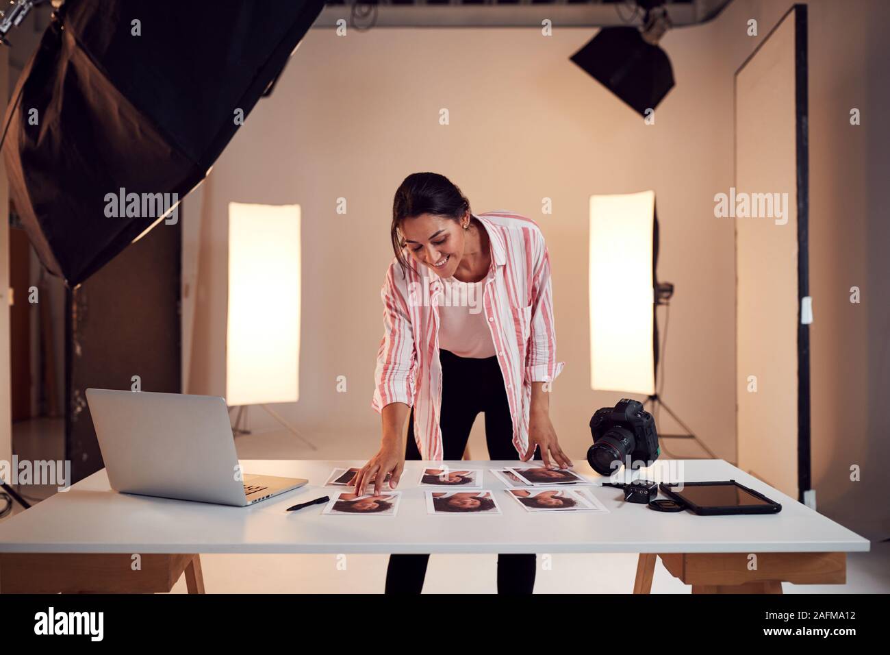 Female Photographer Editing Images From Photo Shoot In Studio Stock ...