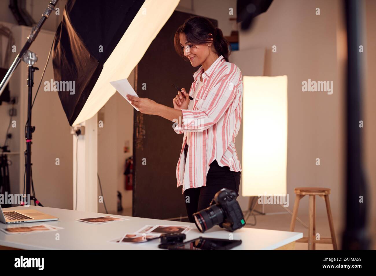 Female Photographer Editing Images From Photo Shoot In Studio Stock ...