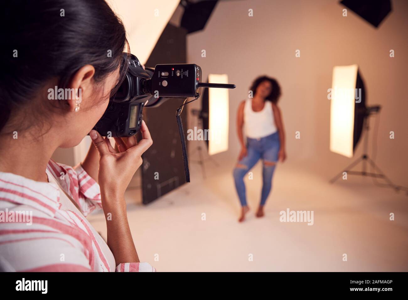 Model Posing For Female Photographer In Studio Portrait Session Stock ...