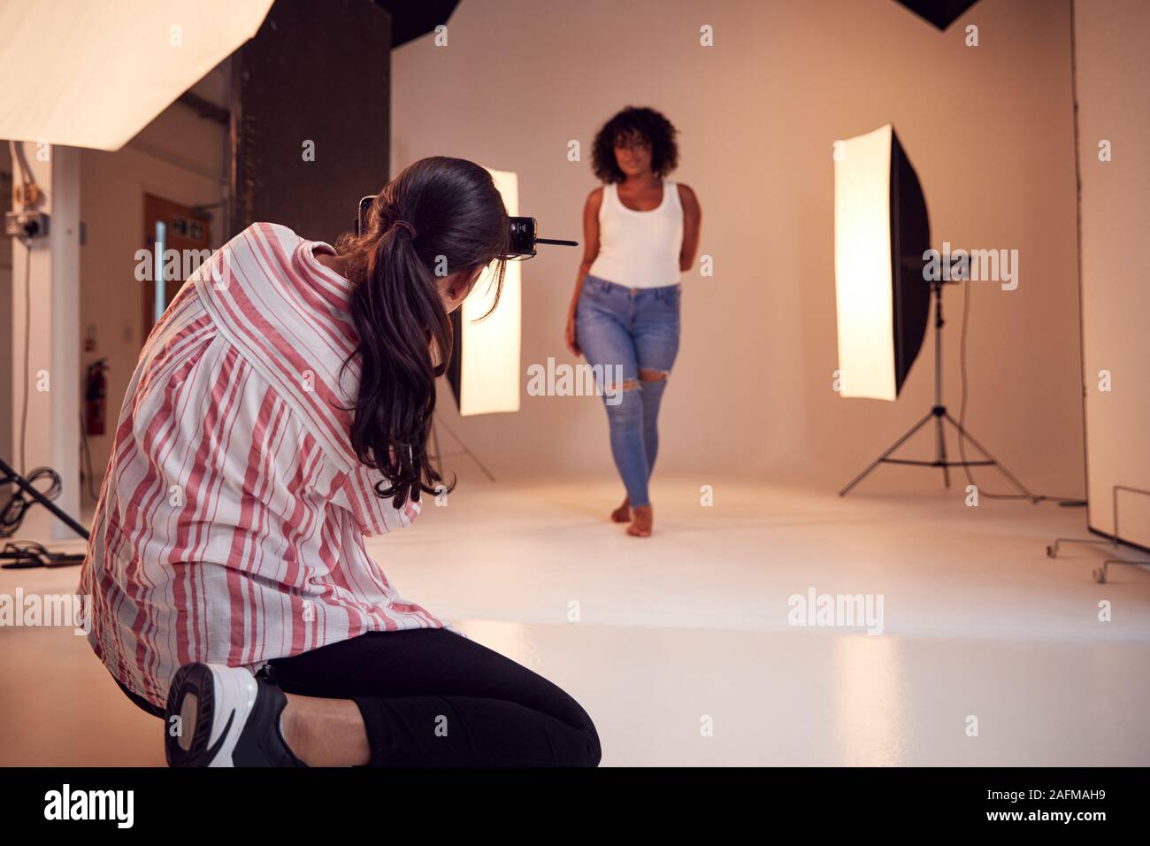 Model Posing For Female Photographer In Studio Portrait Session Stock ...