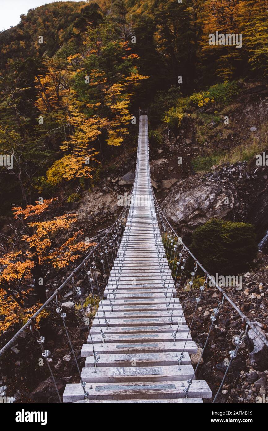 Suspension bridge between rocks next to lake Stock Photo - Alamy