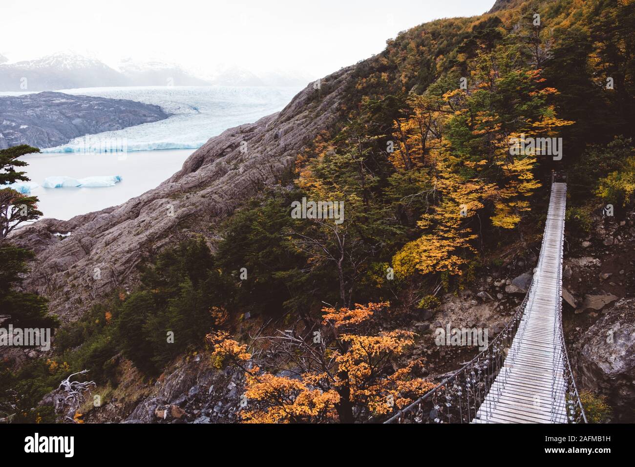 Suspension bridge between rocks next to lake Stock Photo - Alamy