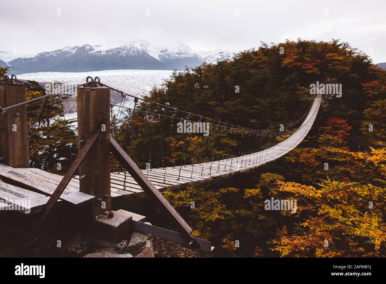 Suspension bridge between rocks next to glacier Stock Photo - Alamy