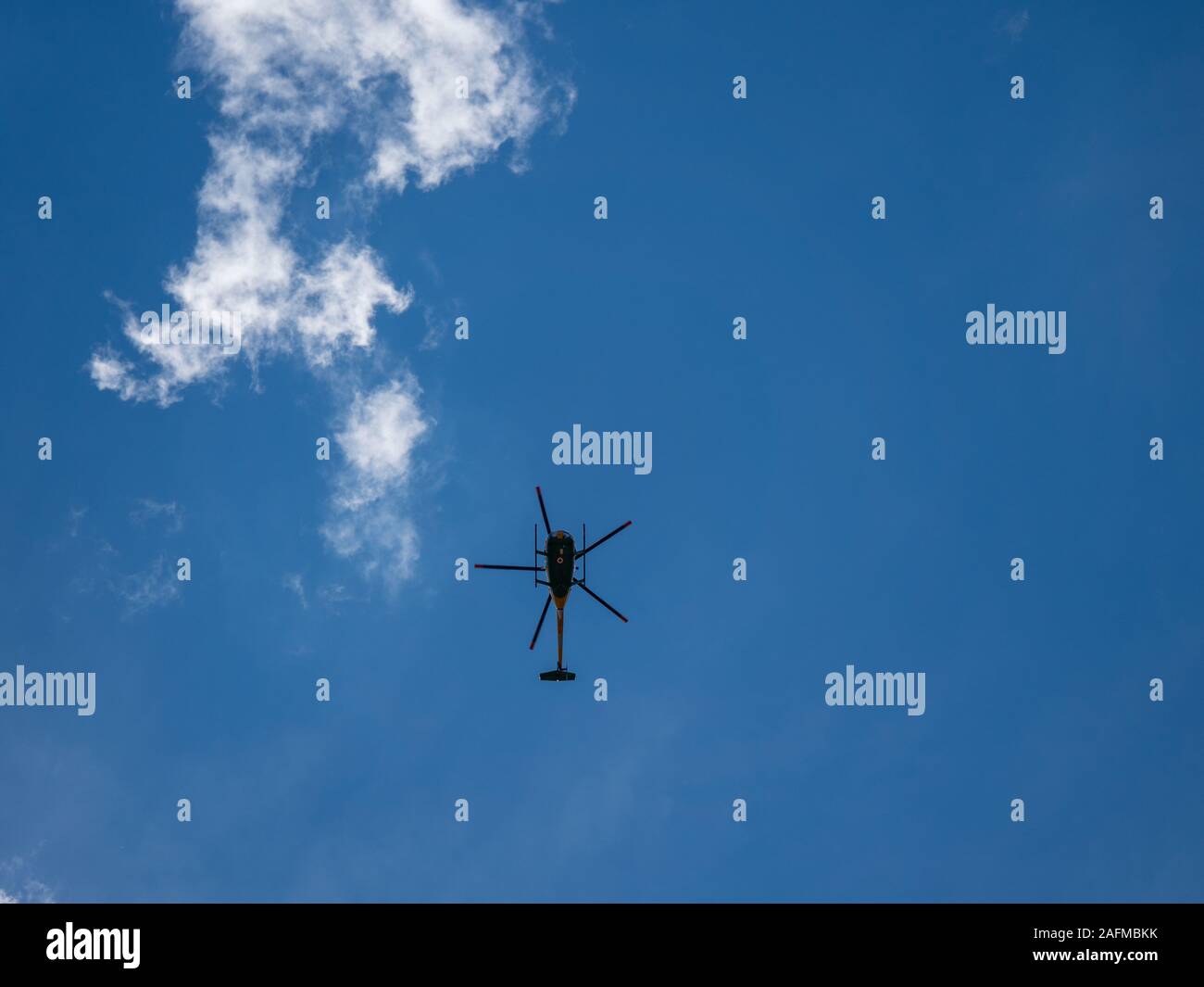 Image of flying helicopter with blue sky from below Stock Photo - Alamy