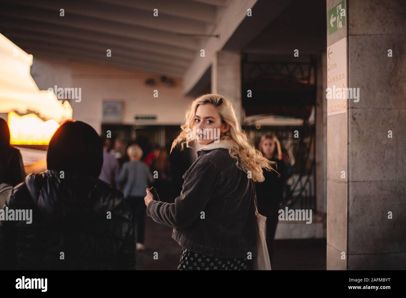 Young woman looking back at camera walking on subway station Stock ...