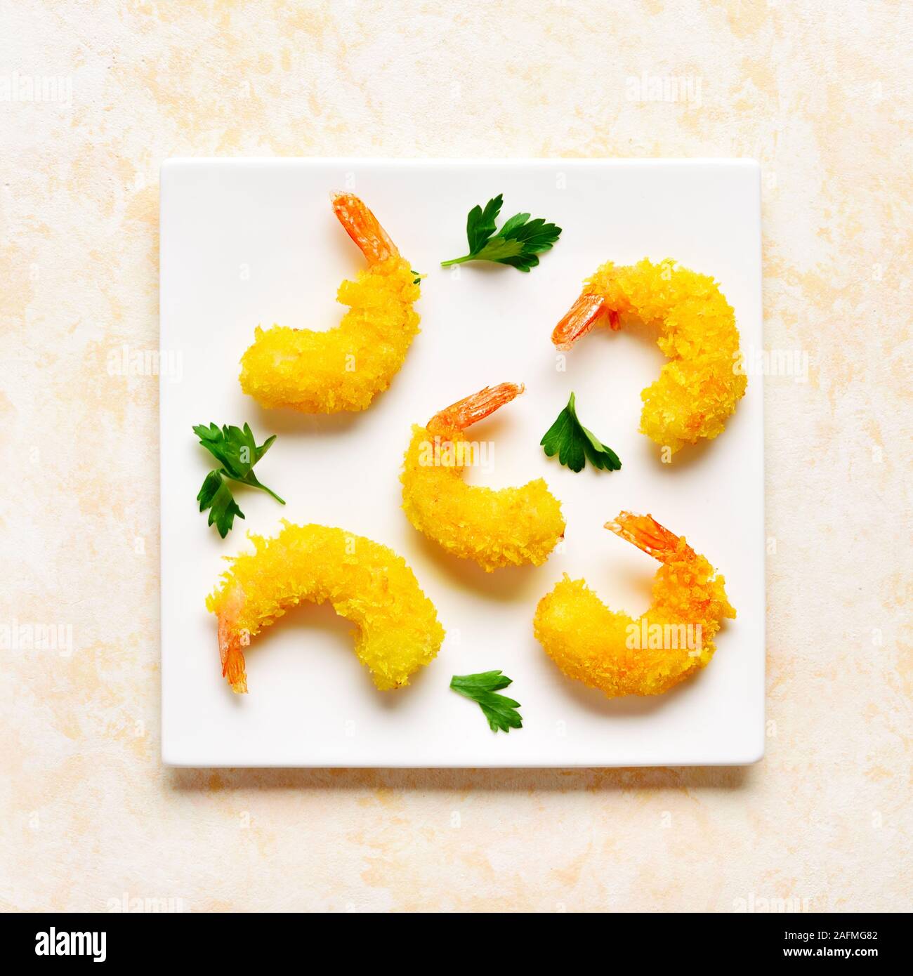 Deep fried breaded prawn on white plate over light stone background ...