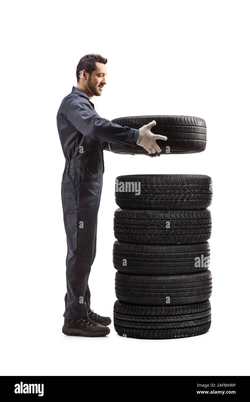 Full length profile shot of an auto mechanic putting car tires in a ...