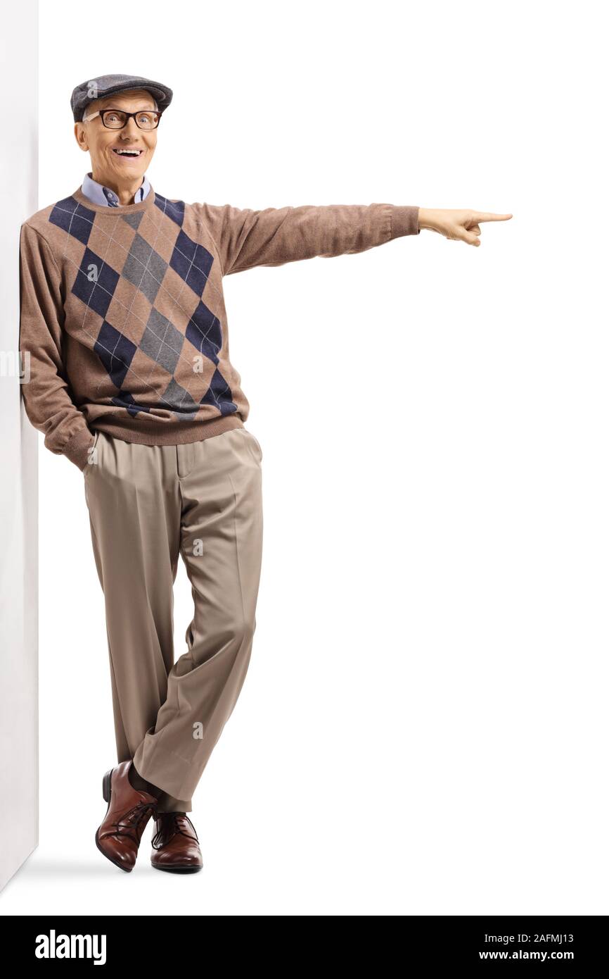 Full length portrait of a senior man leaning on a wall and pointing to ...