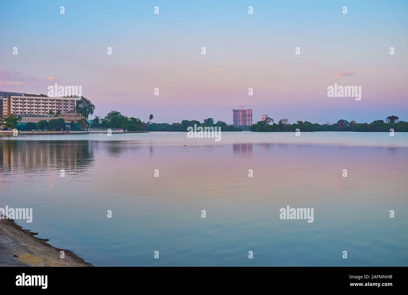 The purple sunset sky is reflected in waters of crystal clear Inya lake ...