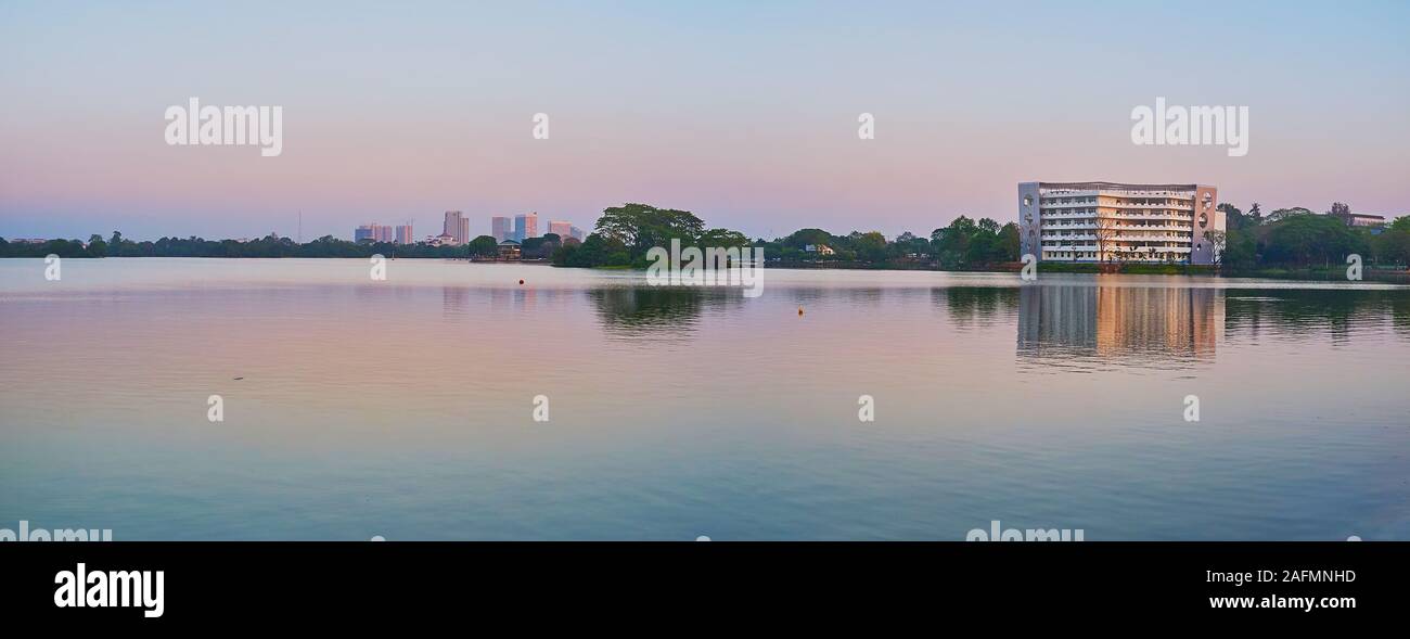 The calm panoramic surface of Inya lake reflects the clear sunset sky ...