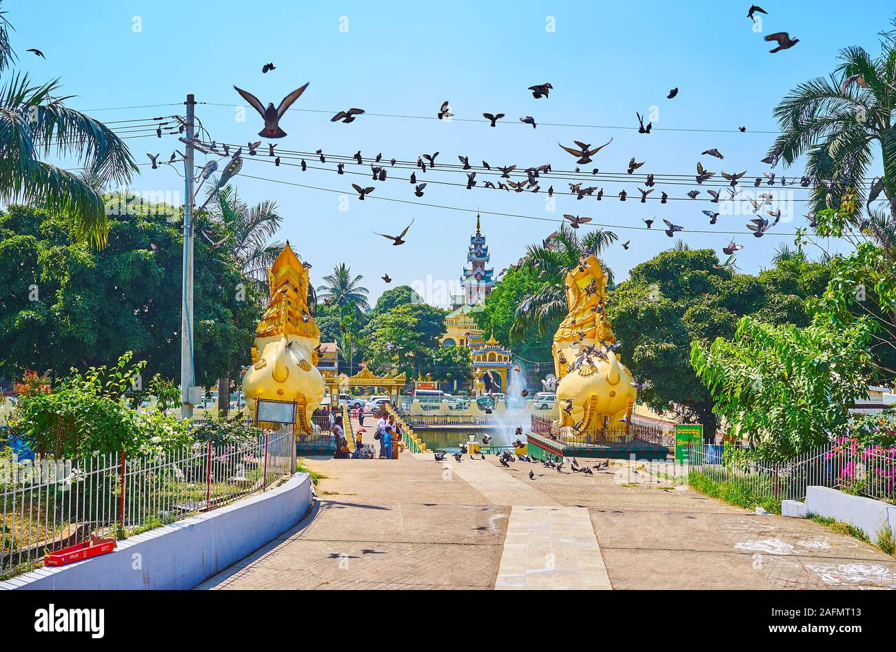YANGON, MYANMAR - FEBRUARY 17, 2018: The flock of flying pigeons above ...