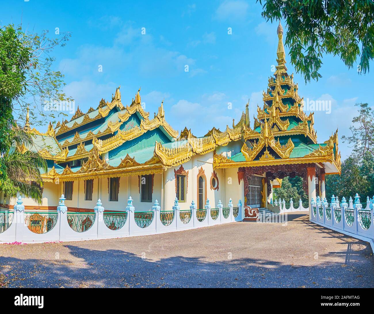 The Tatmadaw hall is decorated wit complex pyathat (multitired) roof, carved hilt bargeboards ...