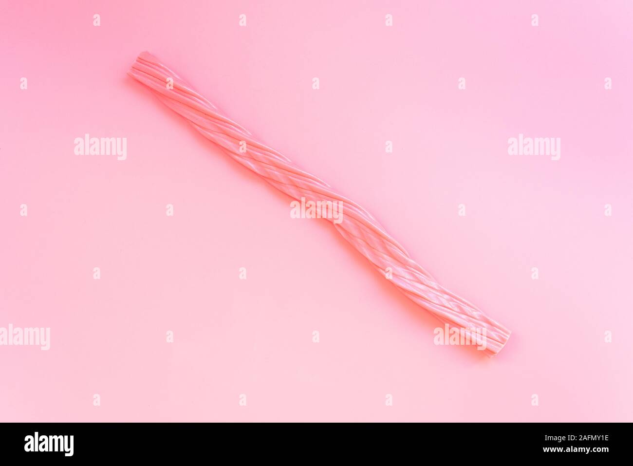 Elongated pink candy isolated on a flat colored background Stock Photo ...