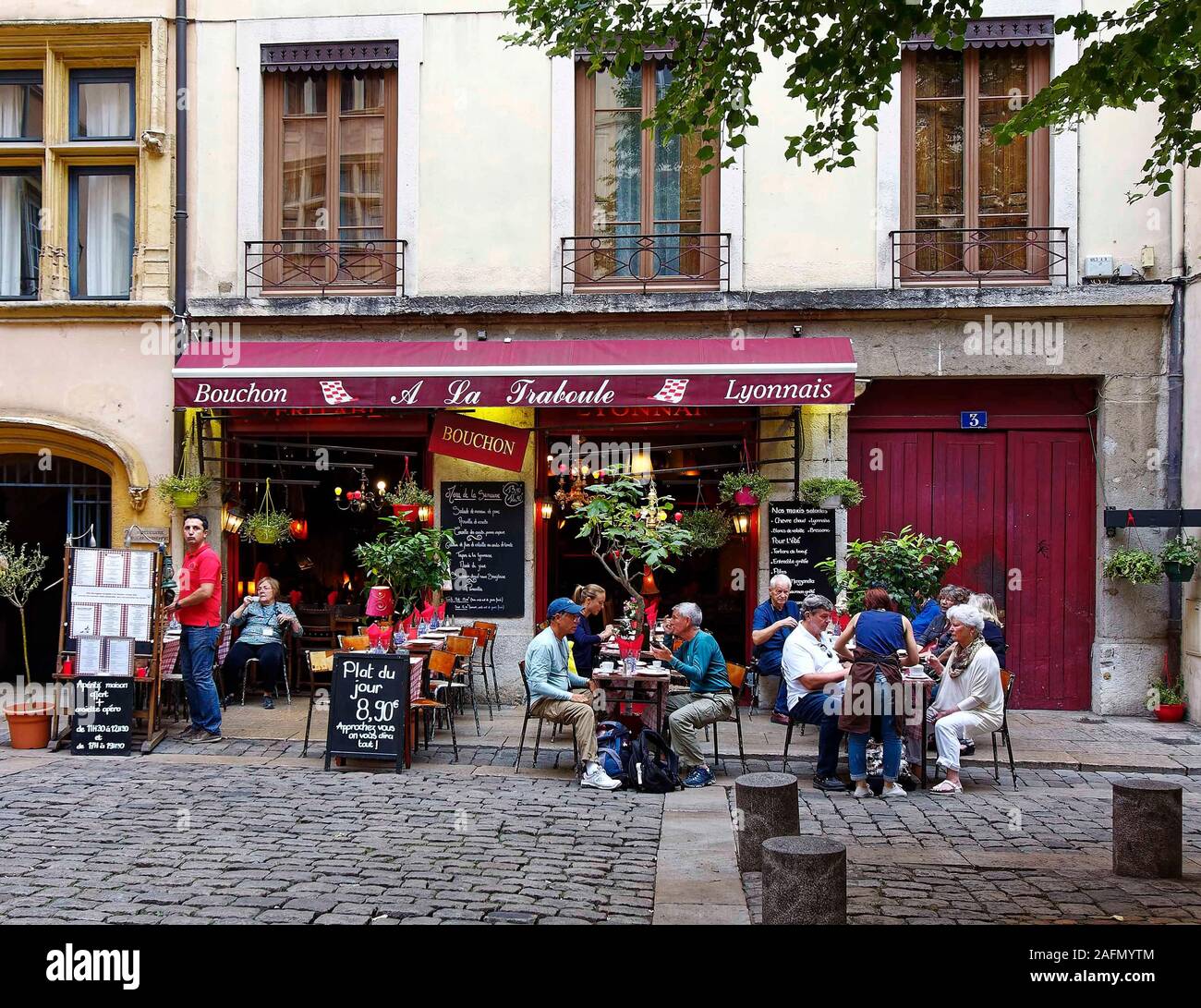 street scene, restaurant, people eating outdoors, cobblestone square ...