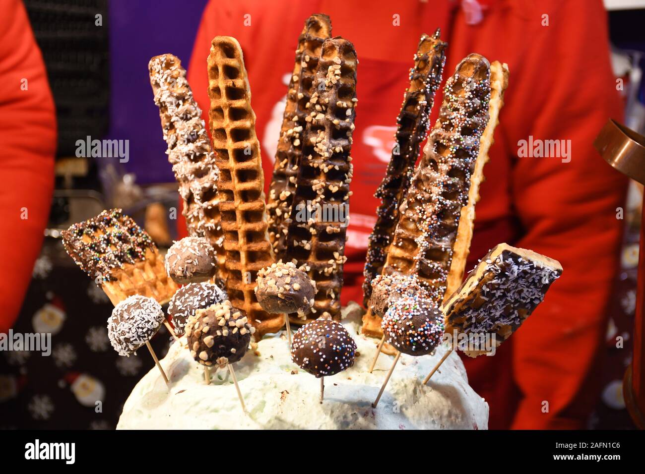 Various delicious waffles on a stick dipped in chocolate or with ...
