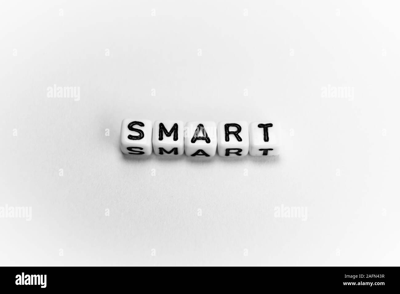 White cubes with word SMART on white paper background and dark shadows ...
