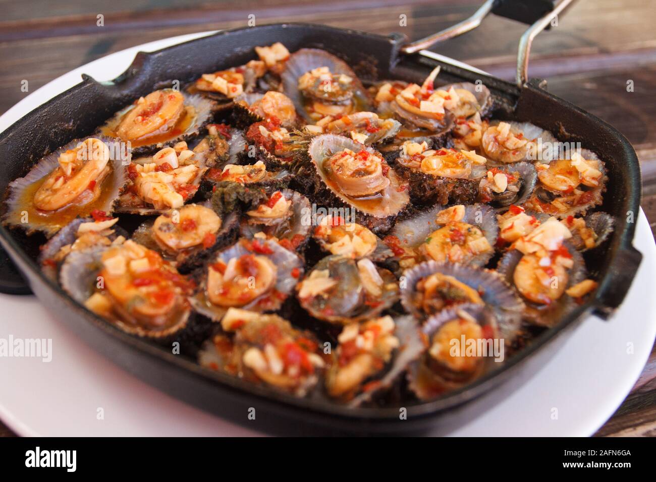 Grilled limpets or Lapas served in cast iron pan, A delicacy of Azores ...