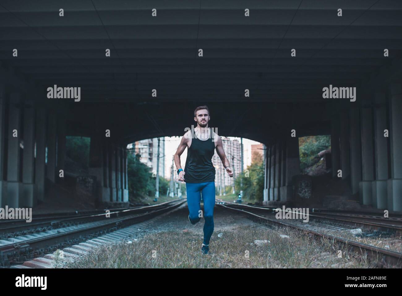 Healthy young man jogging in the city at night. Full length shot of ...