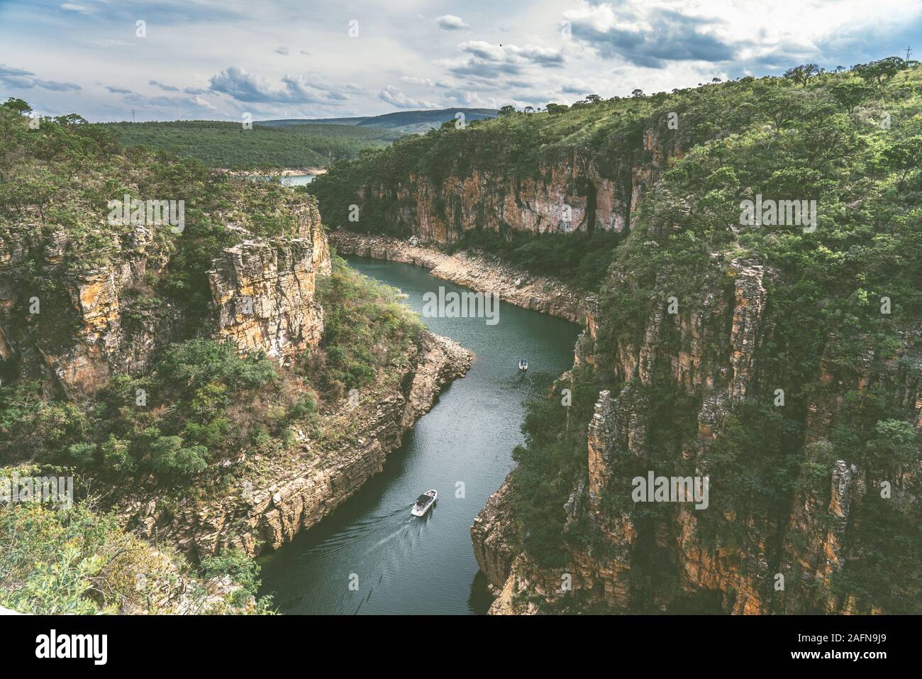 Visitors boats cruising through the canyons of Capitolio in the Serra da Canastra National Park ...