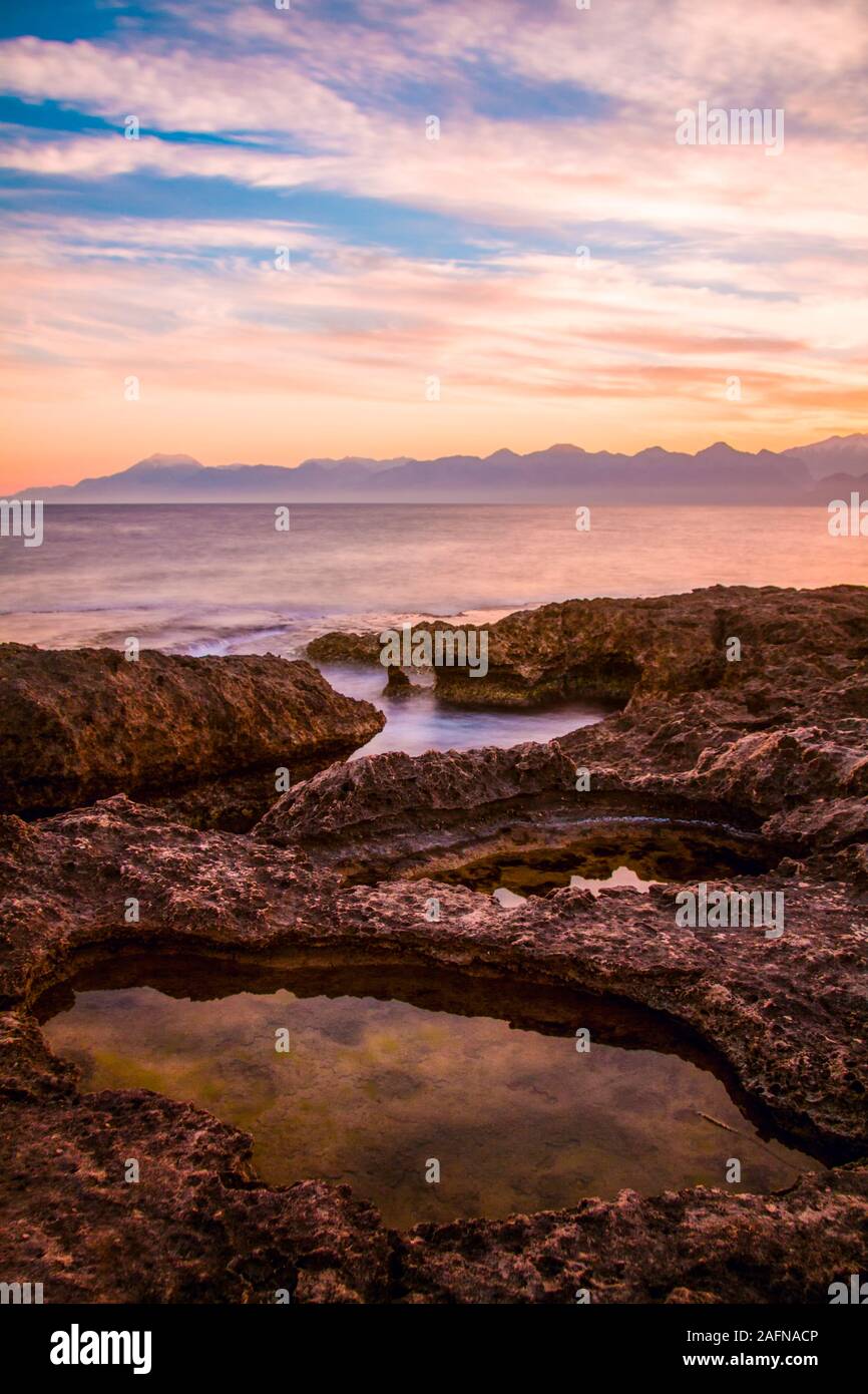 sunset and reflection of puddles on the beach Stock Photo - Alamy