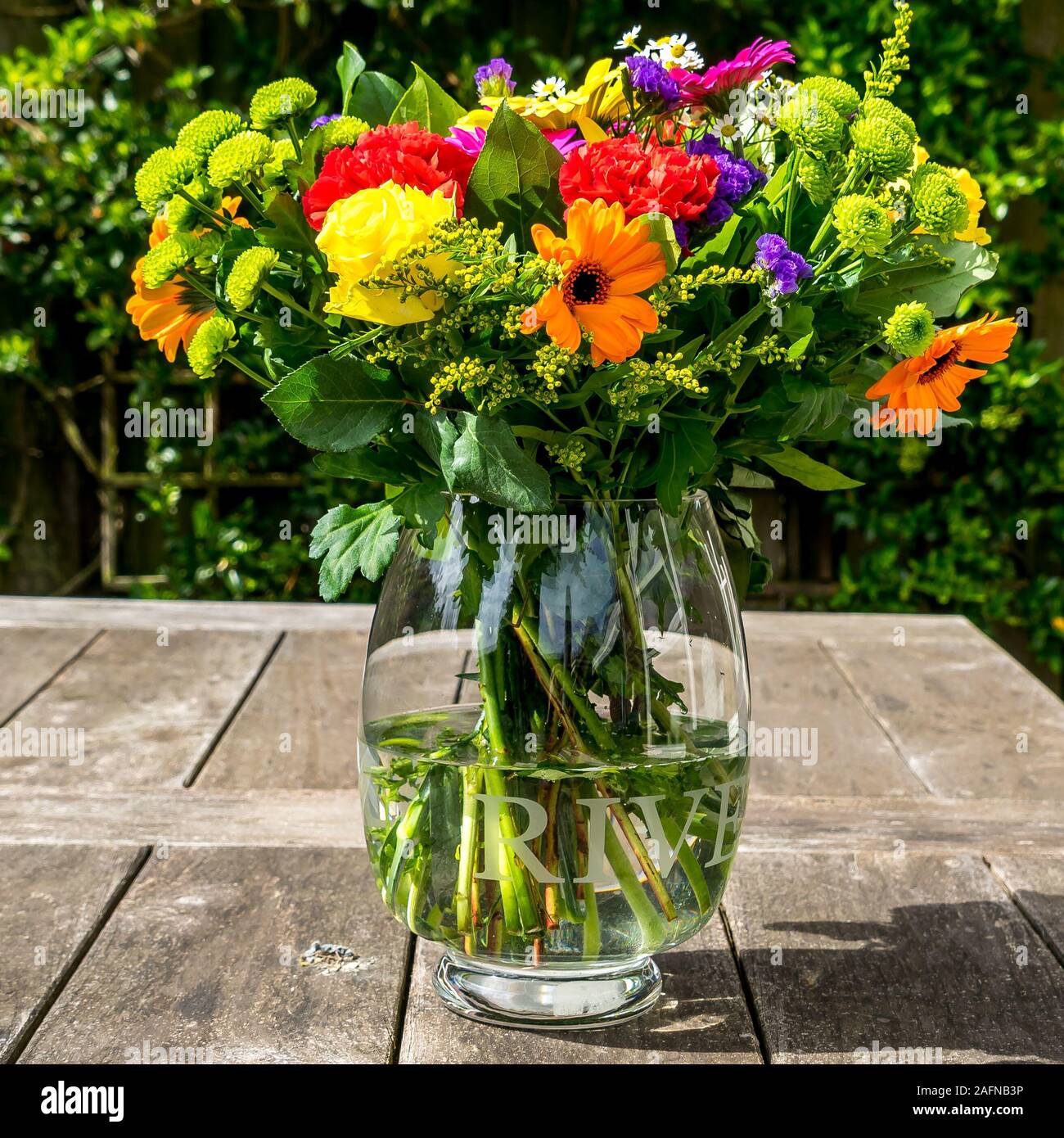 Colorful spring flower bouquet in glass vase front view Stock Photo - Alamy