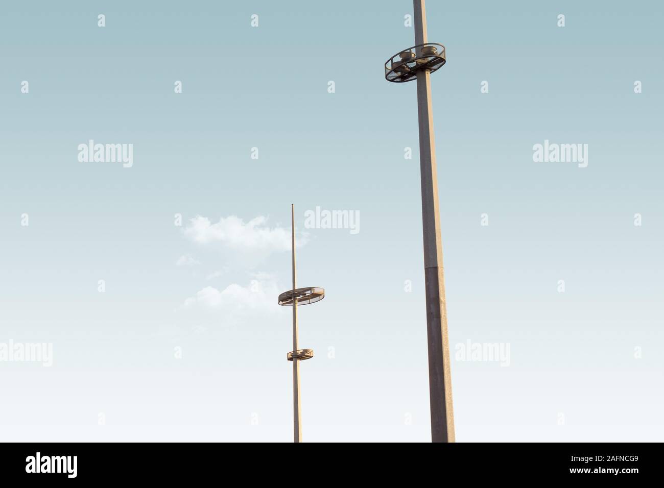 Low angle shot of two lamp post towers under the blue sky Stock Photo ...