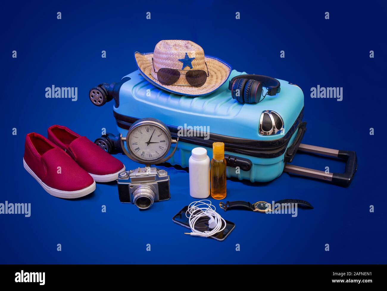 Blue suitcase luggage and travelling objects with trekking slip ...