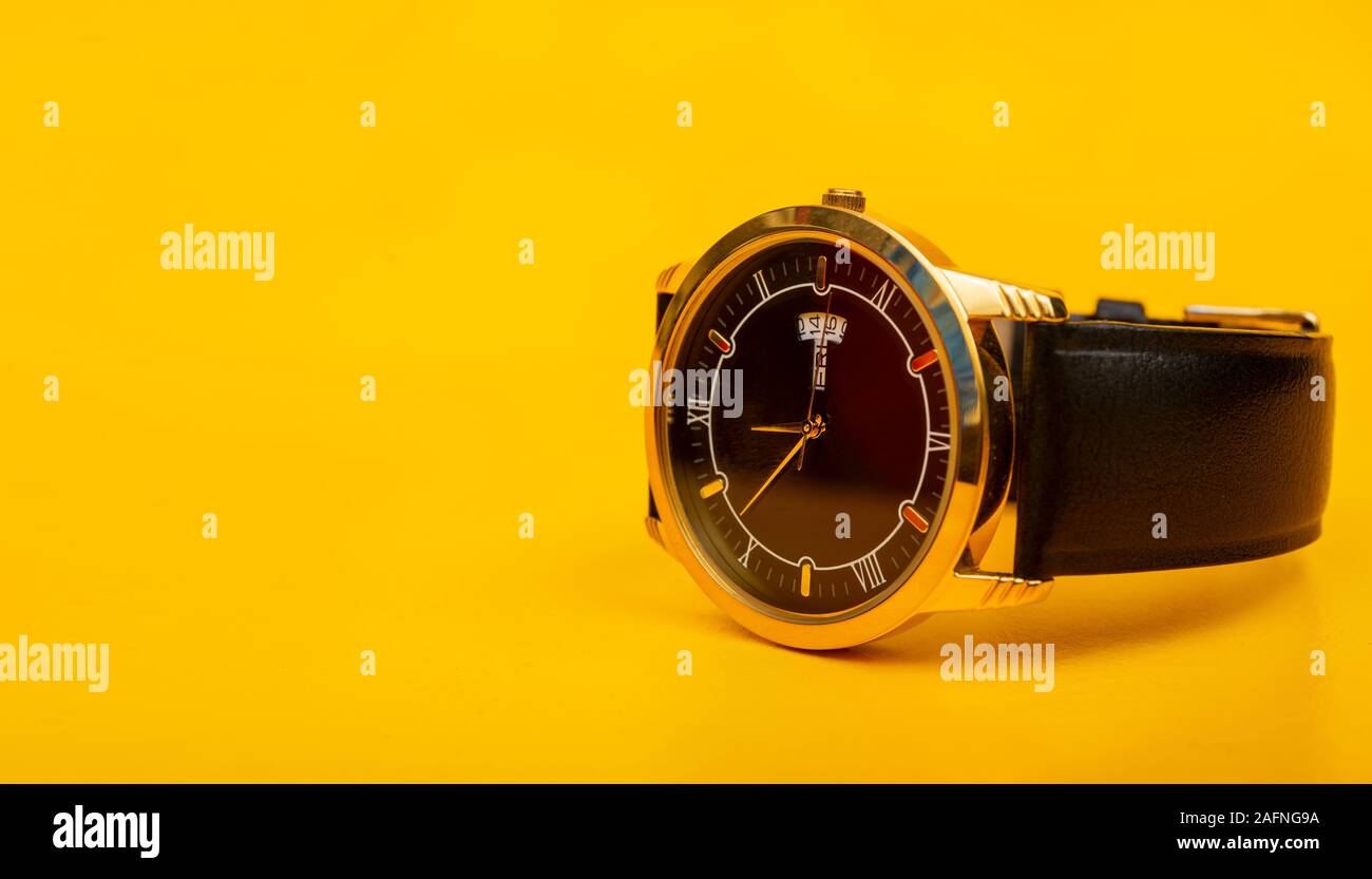 Luxury style golden hand watch top view on yellow background with copy ...