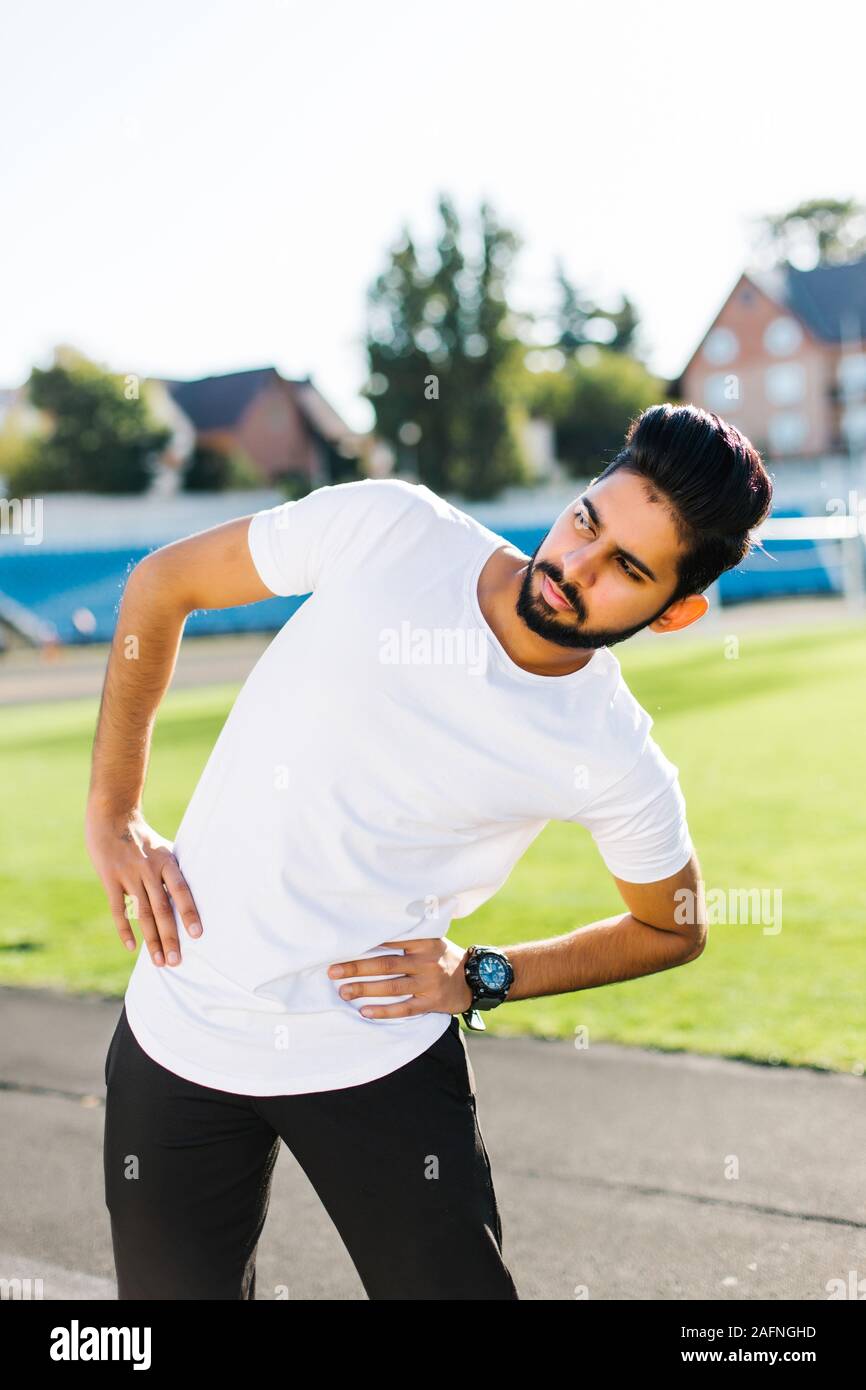 Young athlete stretching on the treadmill stadium Stock Photo - Alamy