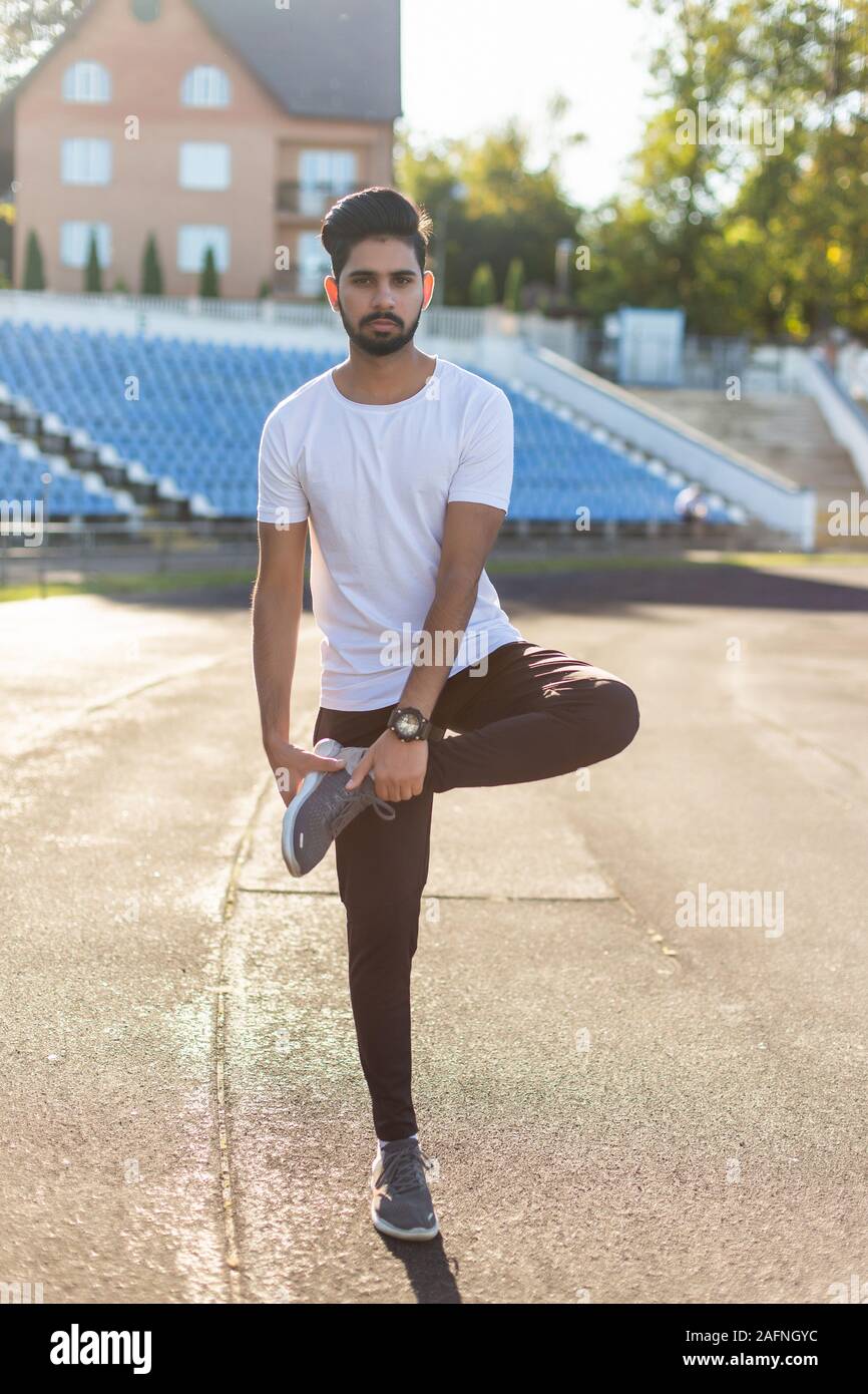 Full length portrait of a athletic man stretching in the morning and ...