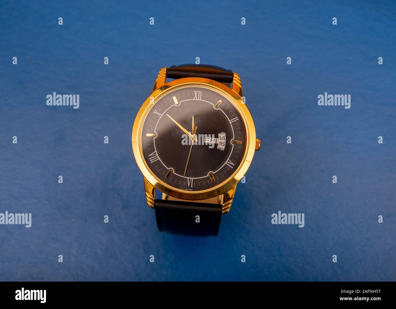 Luxury style golden hand watch top view on blue background with copy ...