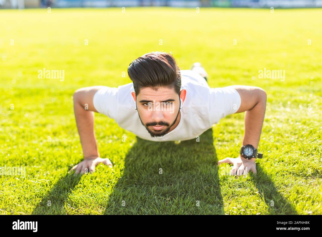 Image of strong shirtless man doing plank exercise at sports stadium ...