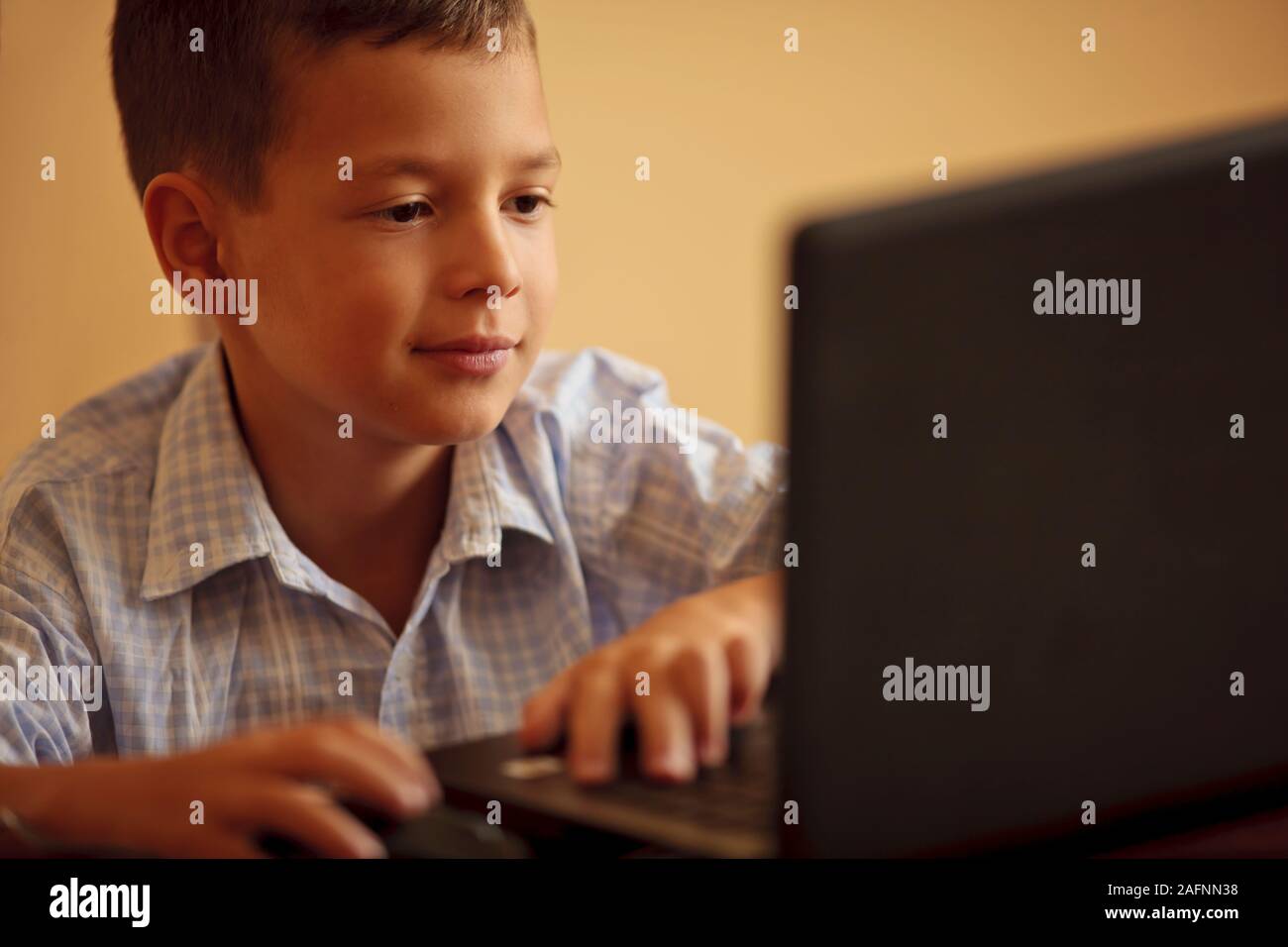 Small boy looking at laptop screen Stock Photo - Alamy